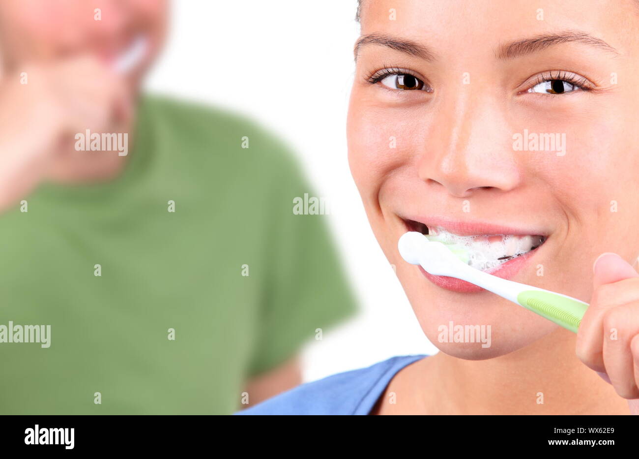 Young couple brushing teeth together on white background Stock Photo ...