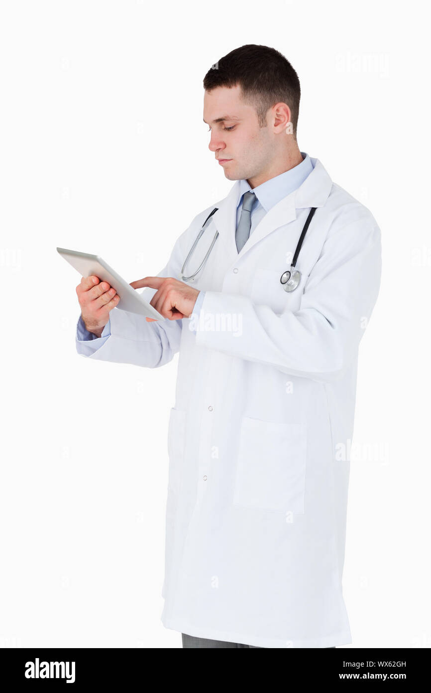 Doctor using his tablet computer against white background Stock Photo ...