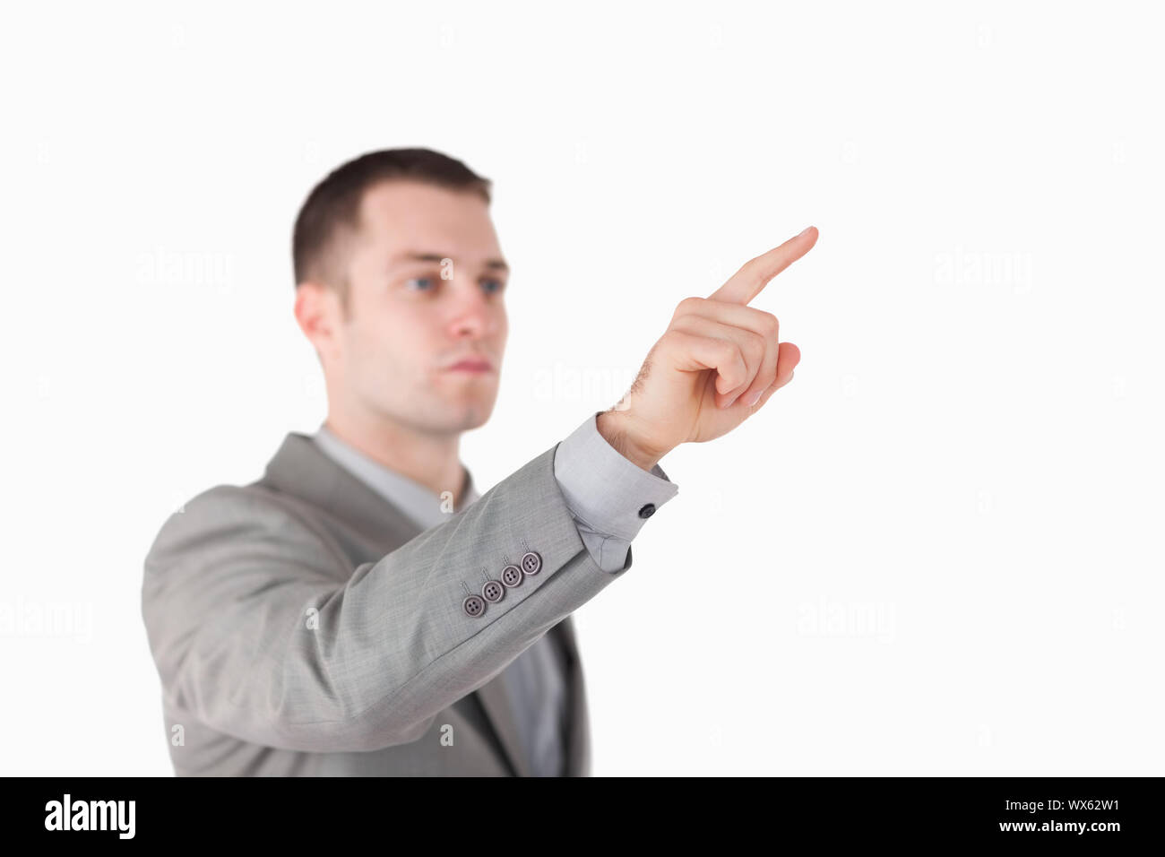 Young businessman touching something against a white background Stock ...