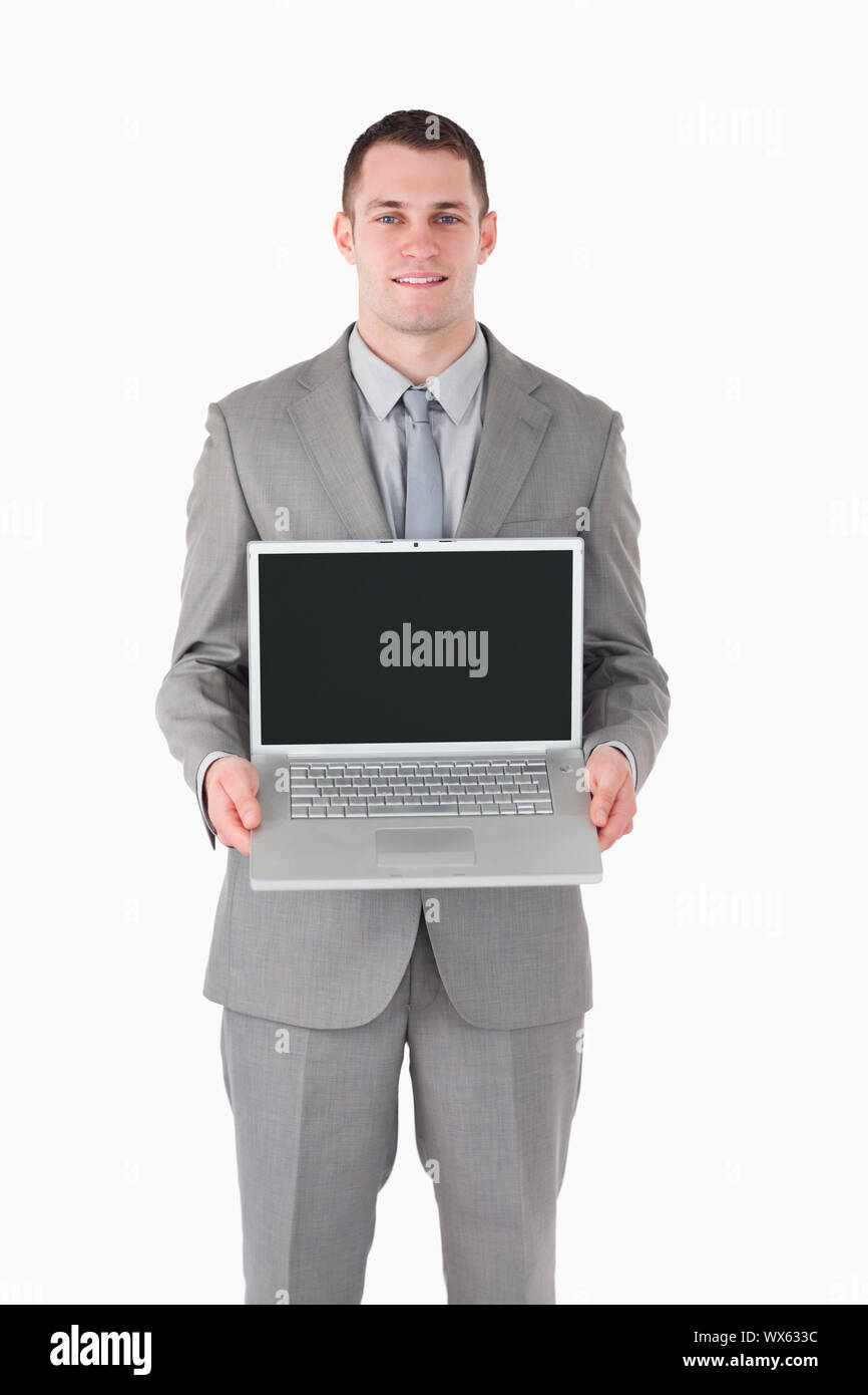 Portrait of a businessman showing a laptop against a white background ...
