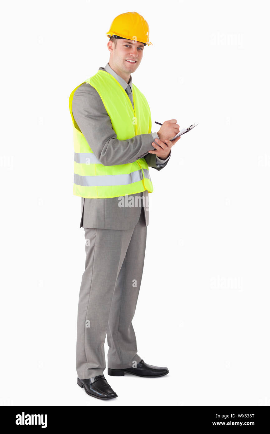 Portrait of a smiling contractor taking notes against a white ...