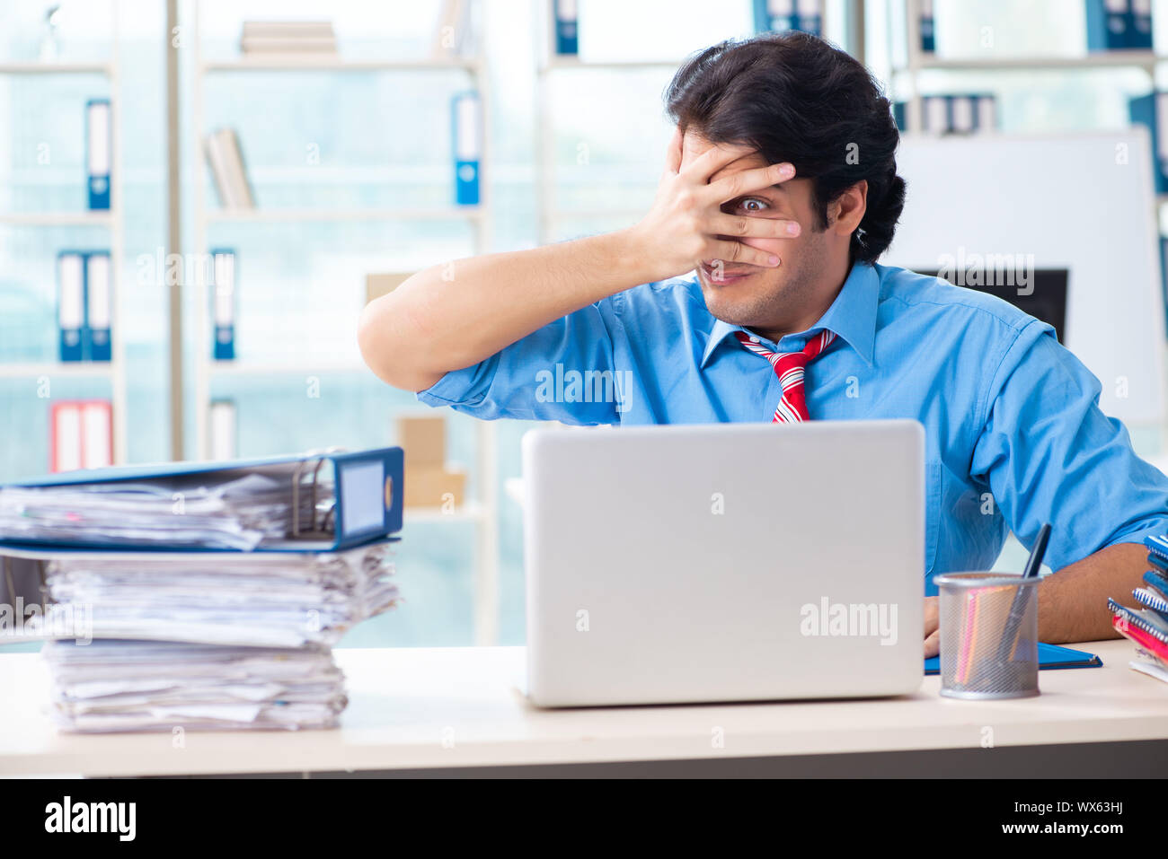 Handsome businessman unhappy with excessive work in the office Stock ...