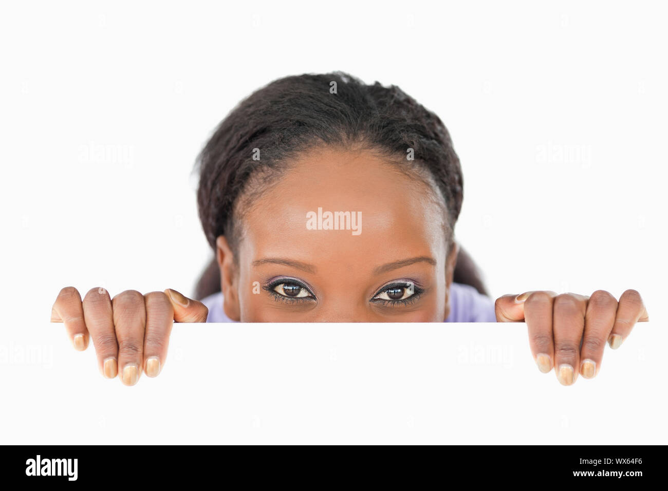 Young woman taking a look above an edge on white background Stock Photo ...