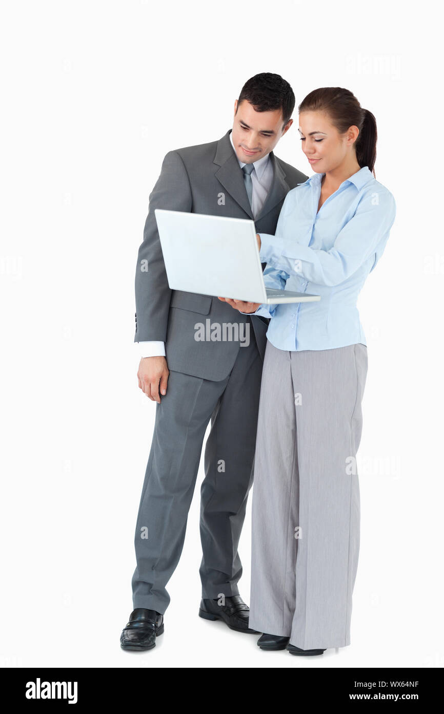 Business partner looking at a notebook together against a white ...