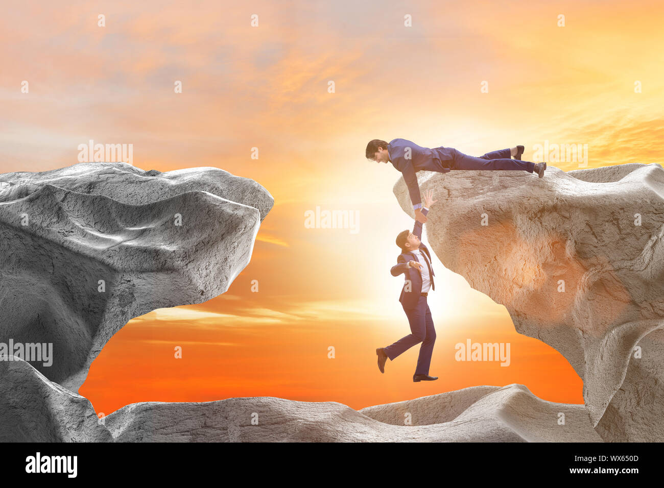 Businessman offering helping hand to falling colleague Stock Photo - Alamy