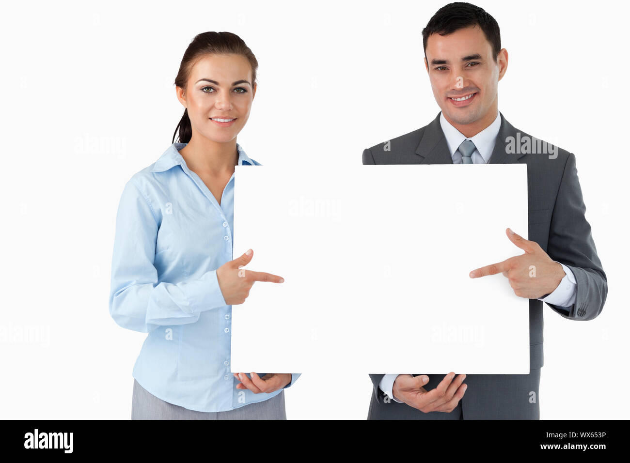 Business partners presenting sign together against a white background ...