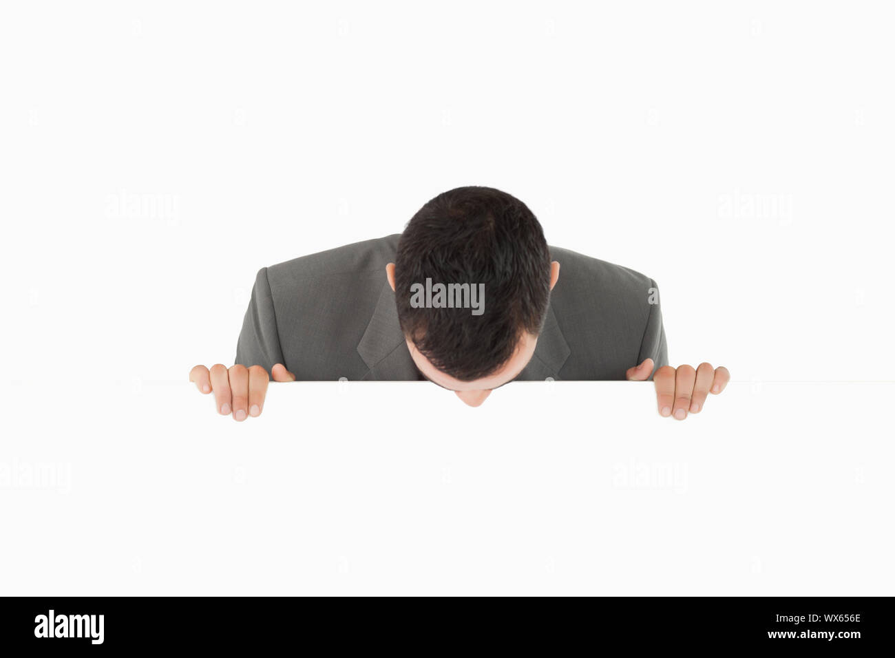 Businessman looking down on sign against a white background Stock Photo ...