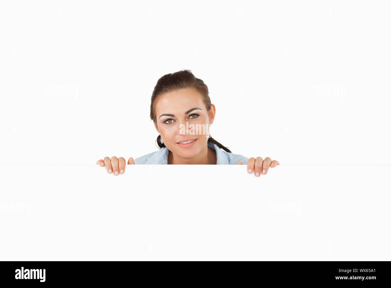 Businesswoman looking over wall against a white background Stock Photo ...