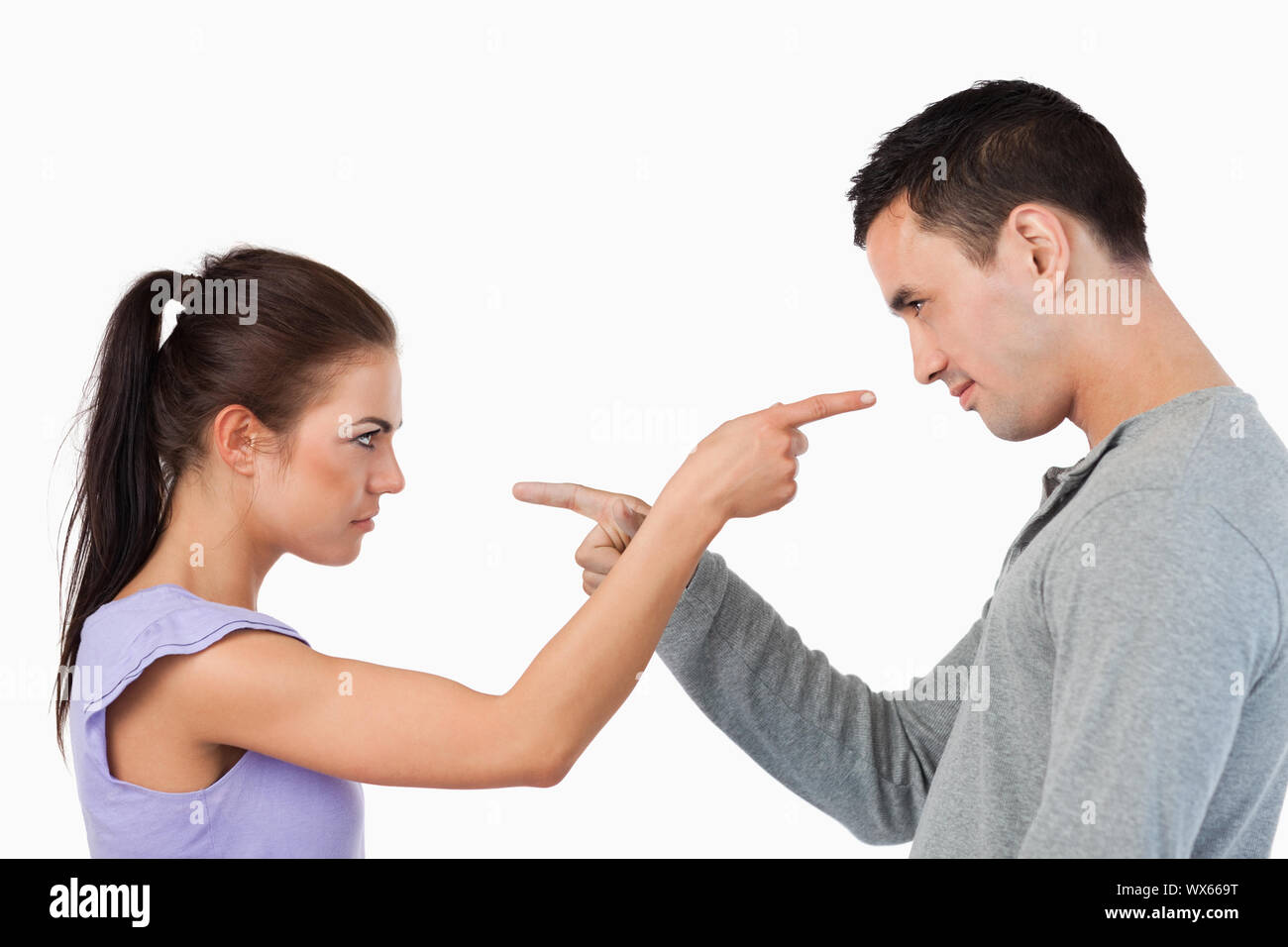 Young couple pointing at each other against a white background Stock ...