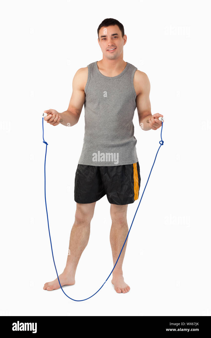 Young sportsman preparing for jump roping against a white background ...