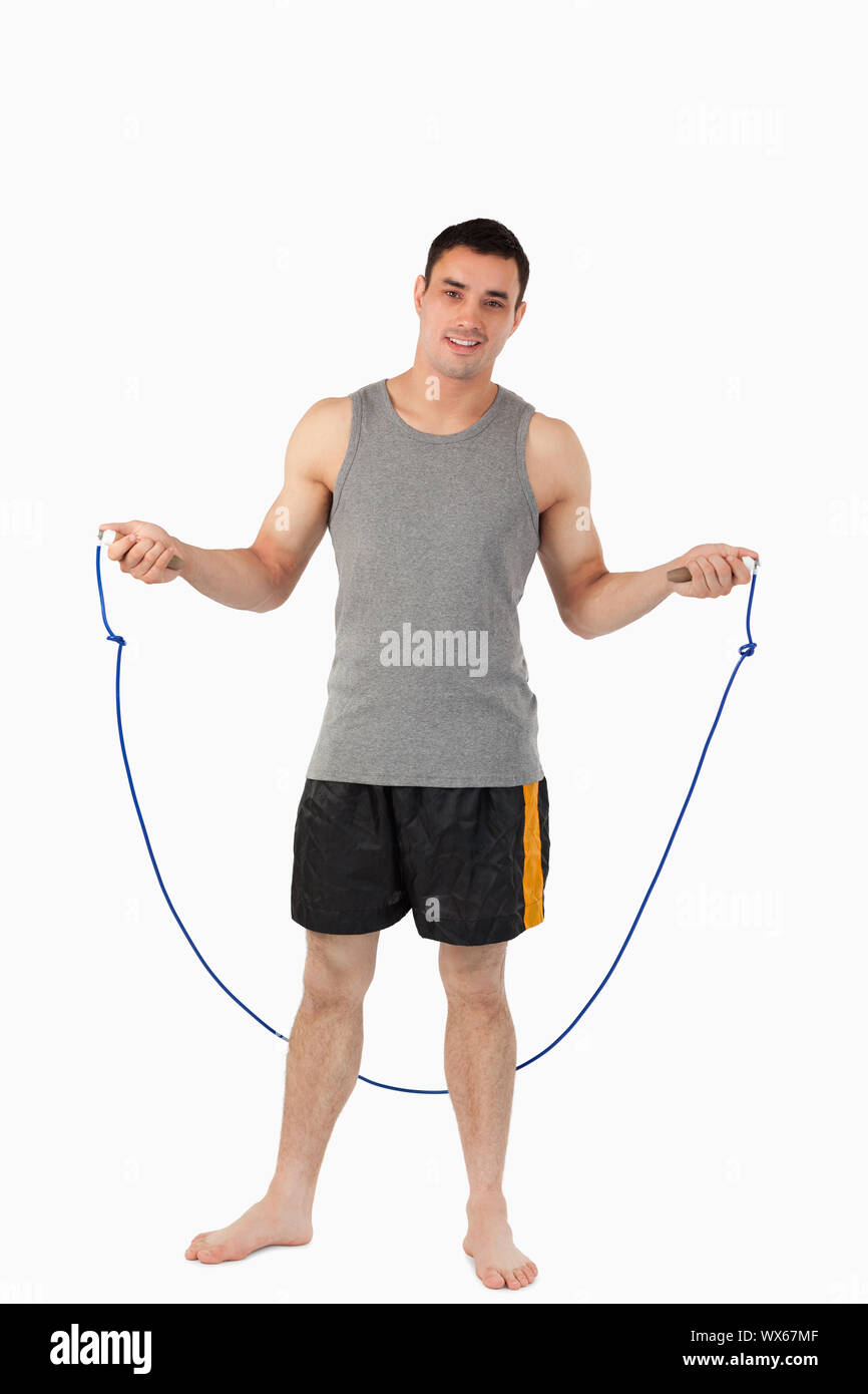 Young sportsman about to start rope jumping against a white background ...