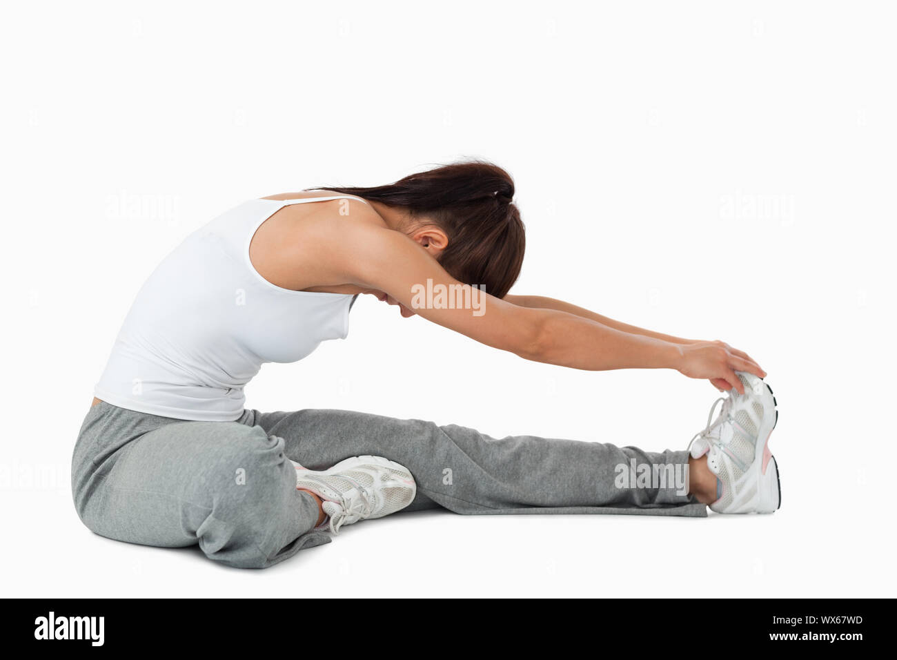 Side view of woman stretching against a white background Stock Photo ...