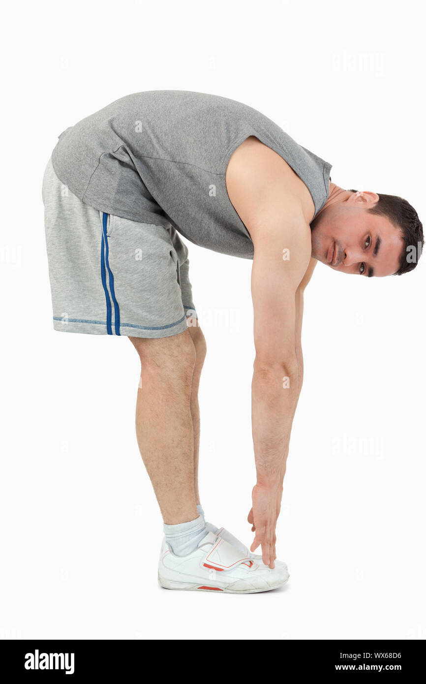 Portrait of a man stretching up against a white background Stock Photo ...