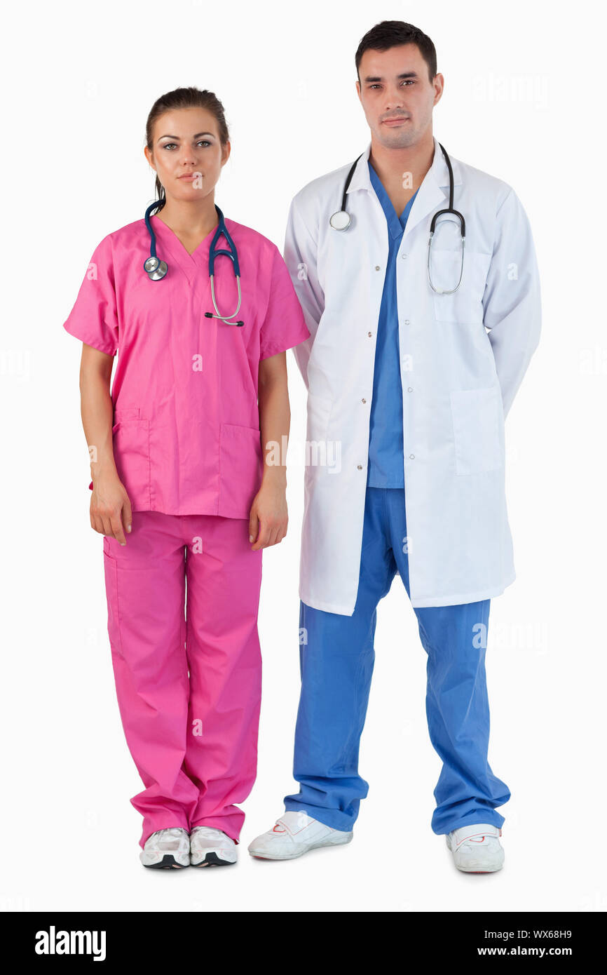 Portrait of serious doctors standing up against a white background ...