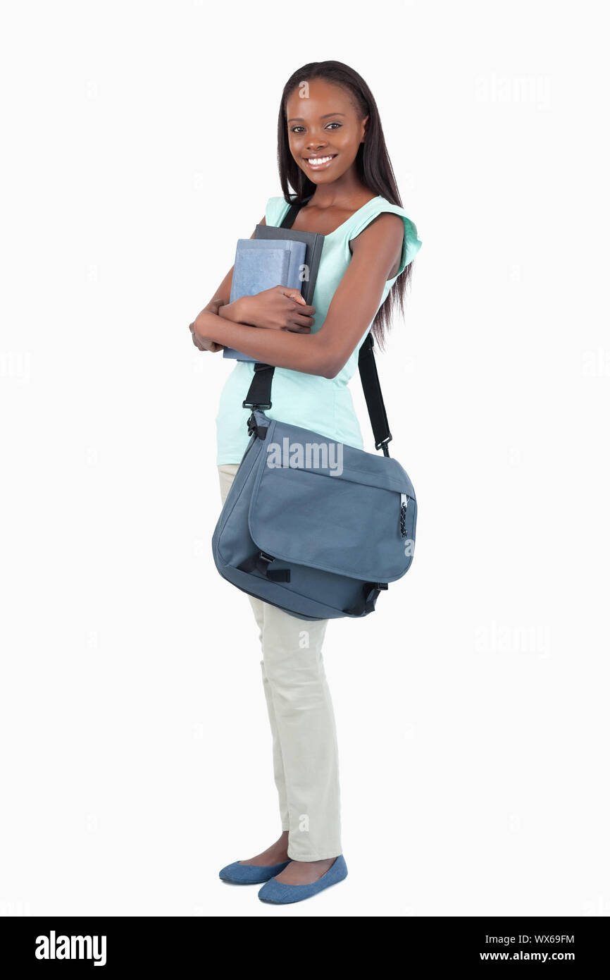 Side view of young female student ready for class against a white ...