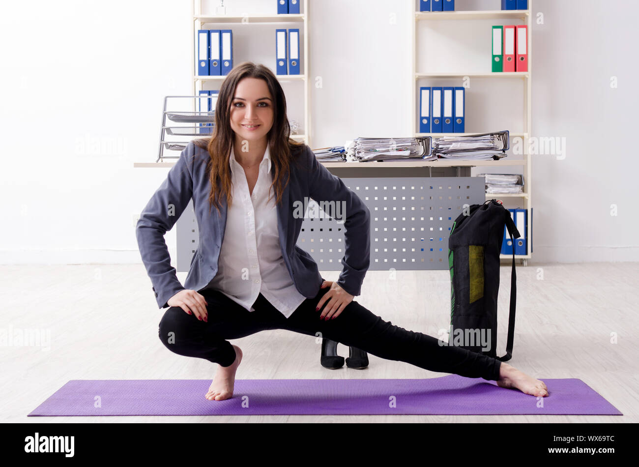 Female employee doing sport exercises in the office Stock Photo - Alamy