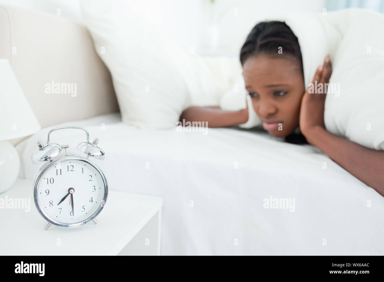 Woman being awakened by her alarm clock in her bedroom Stock Photo - Alamy