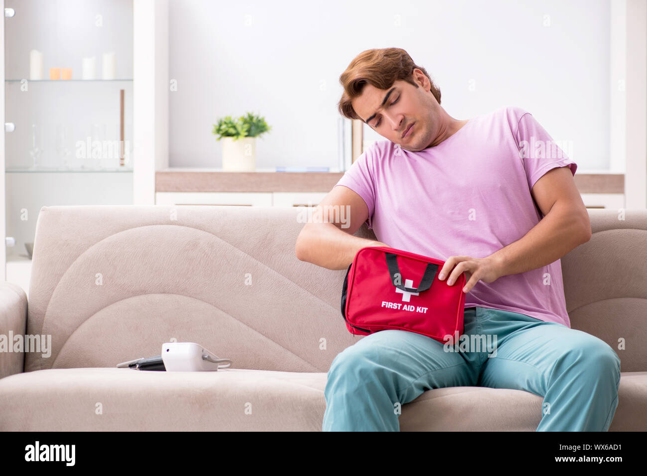 Sick man at home with first aid kit Stock Photo - Alamy