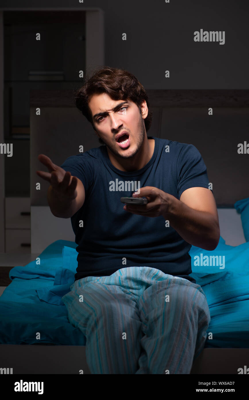 Man watching tv at night in bed Stock Photo - Alamy