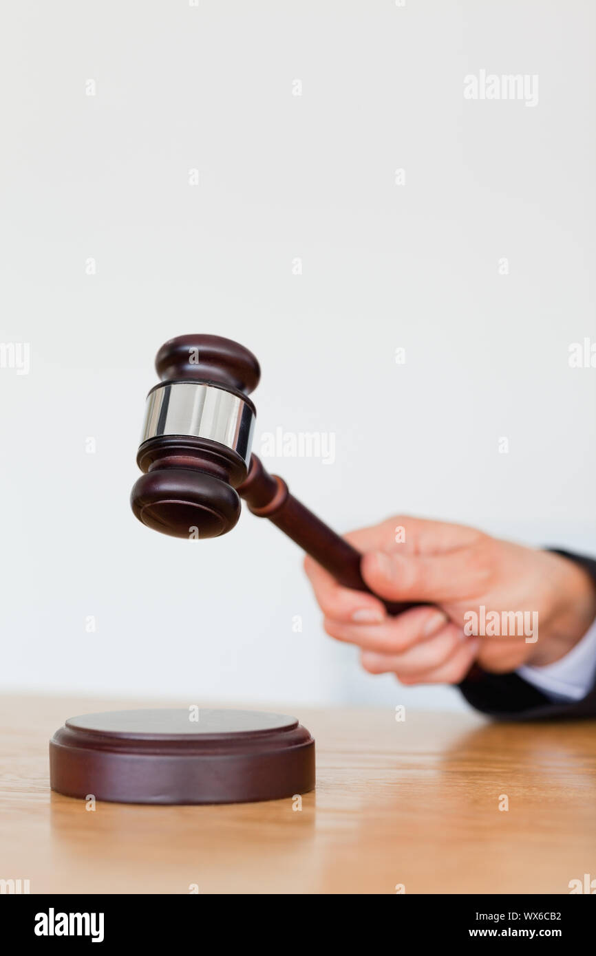 Portrait of a hand knocking a gavel against a white background Stock ...