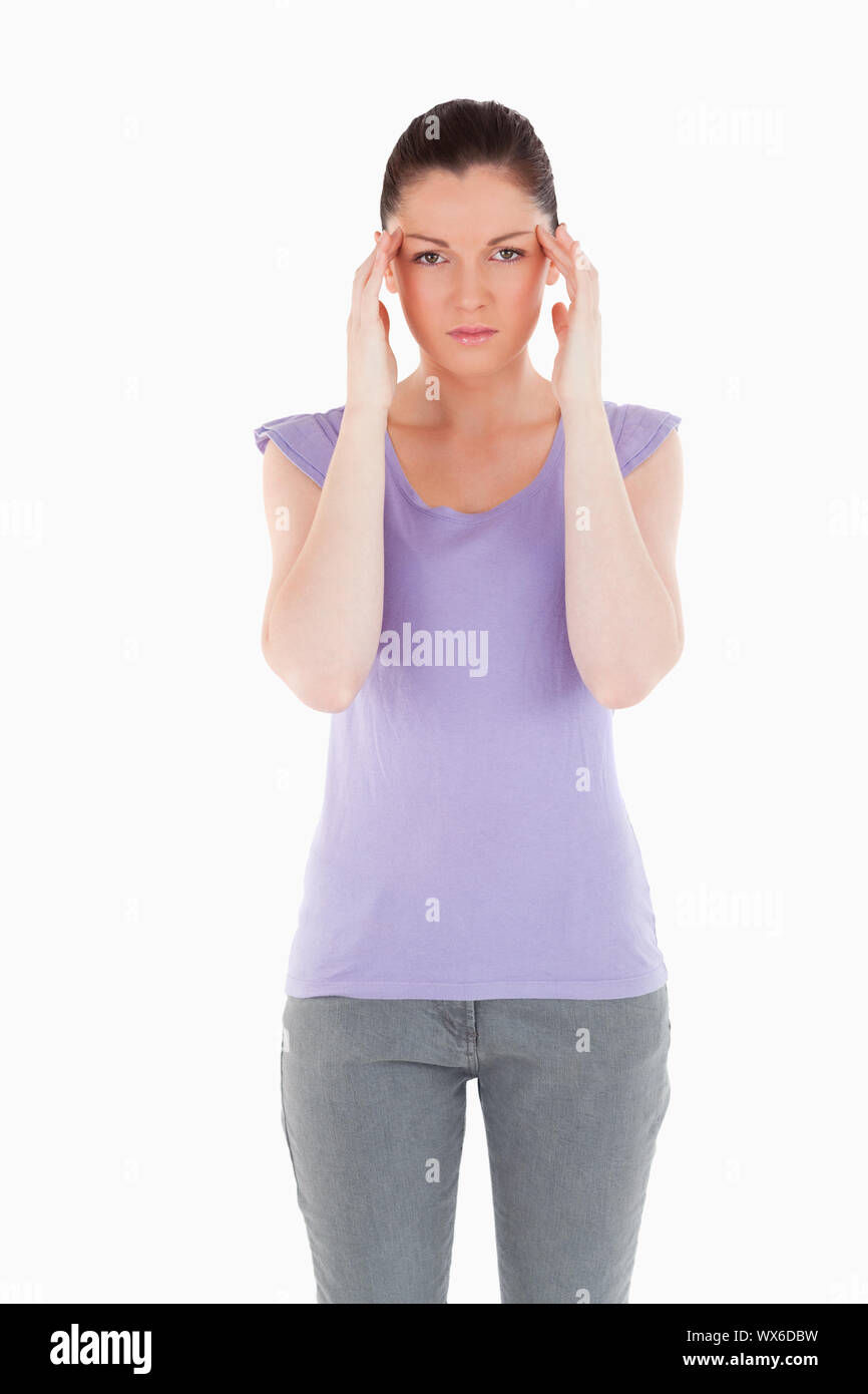 Lovely woman having a headache while standing against a white ...