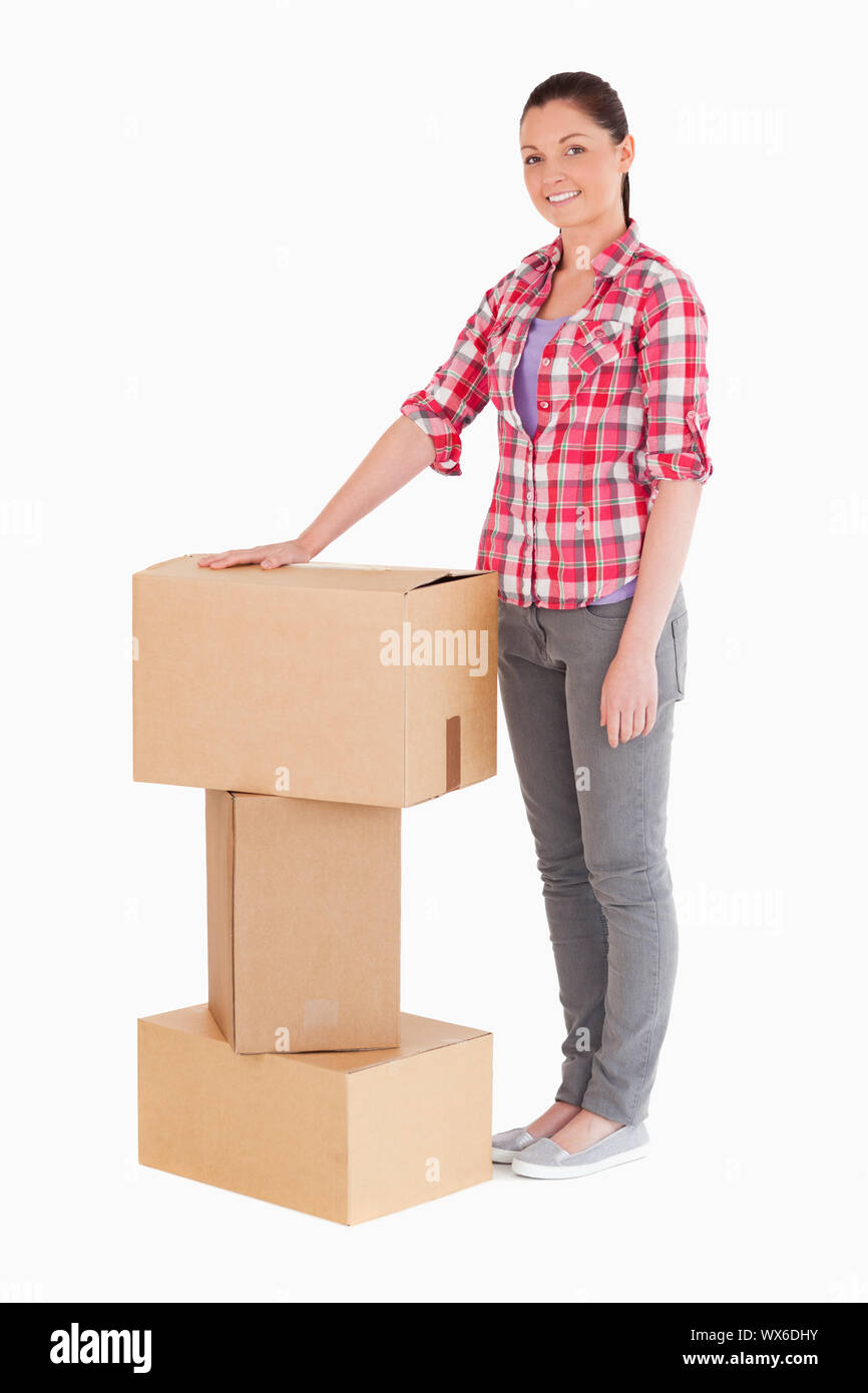 Beautiful woman posing with cardboard boxes while standing against a ...
