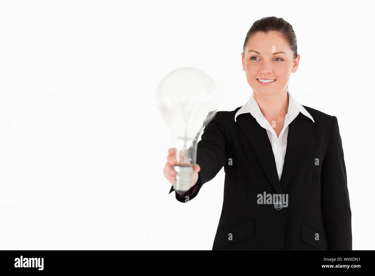 Charming woman in suit holding a light bulb while standing against a ...