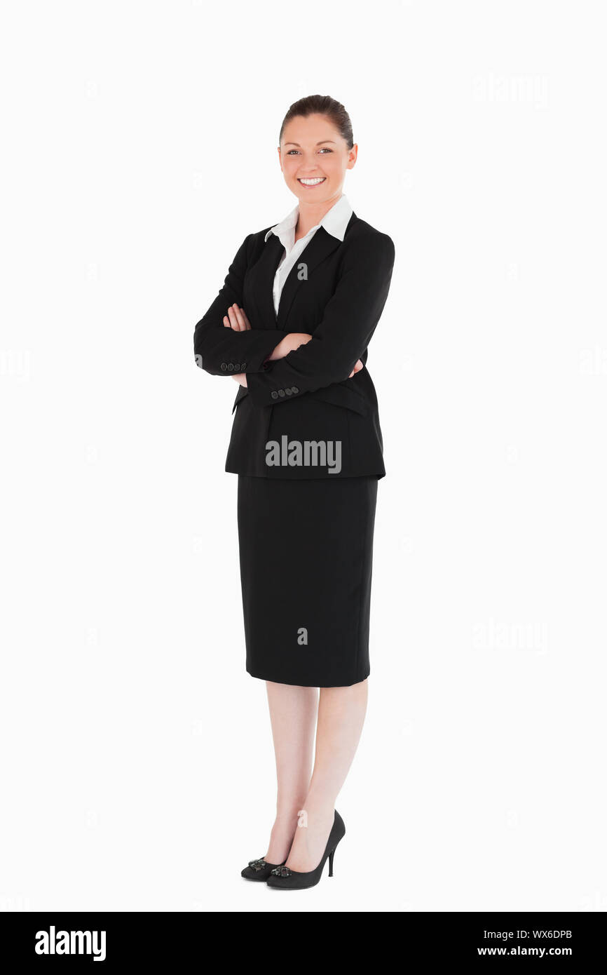 Attractive female in suit posing while standing against a white ...