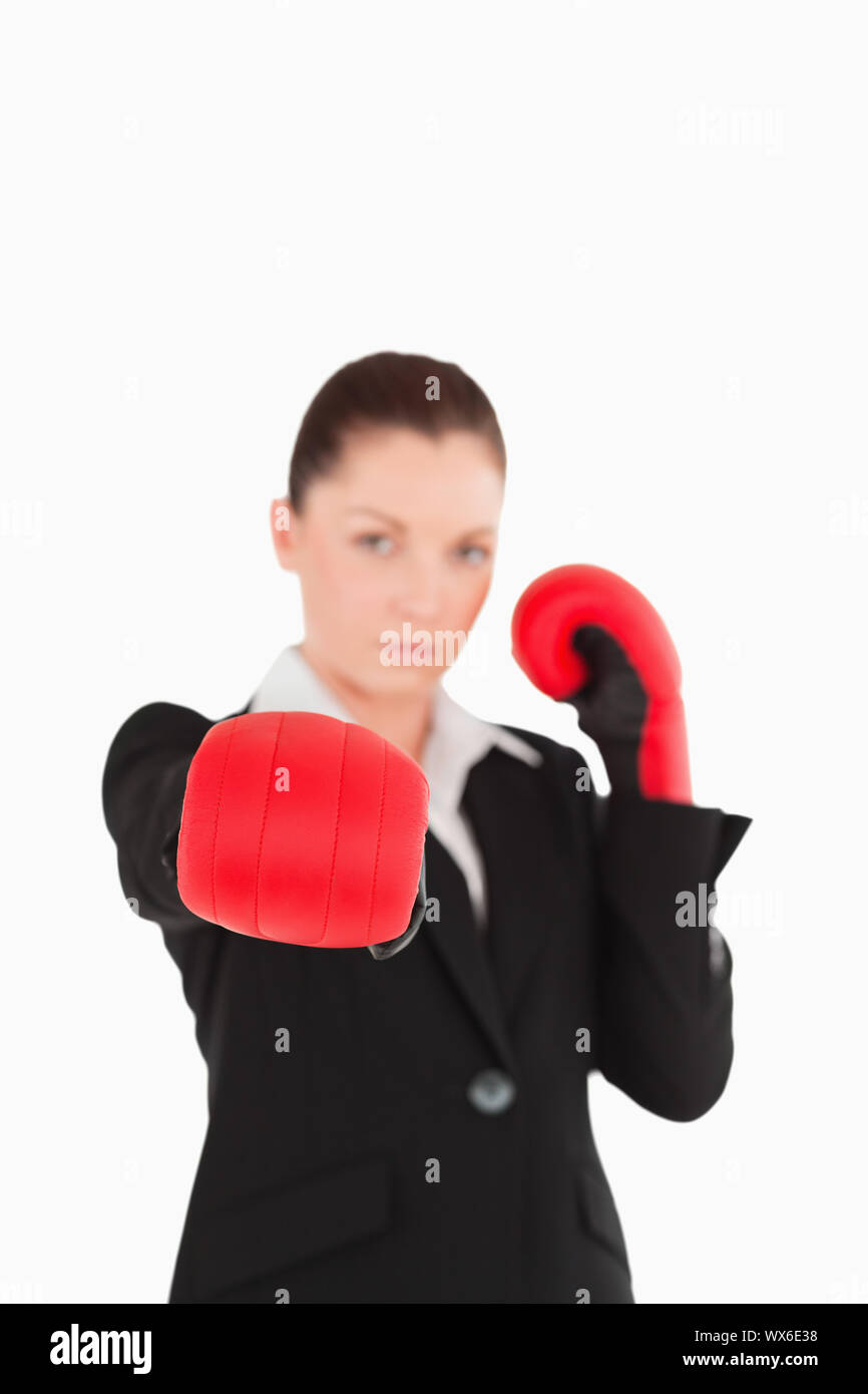 Cute woman wearing some boxing gloves while standing against a white ...