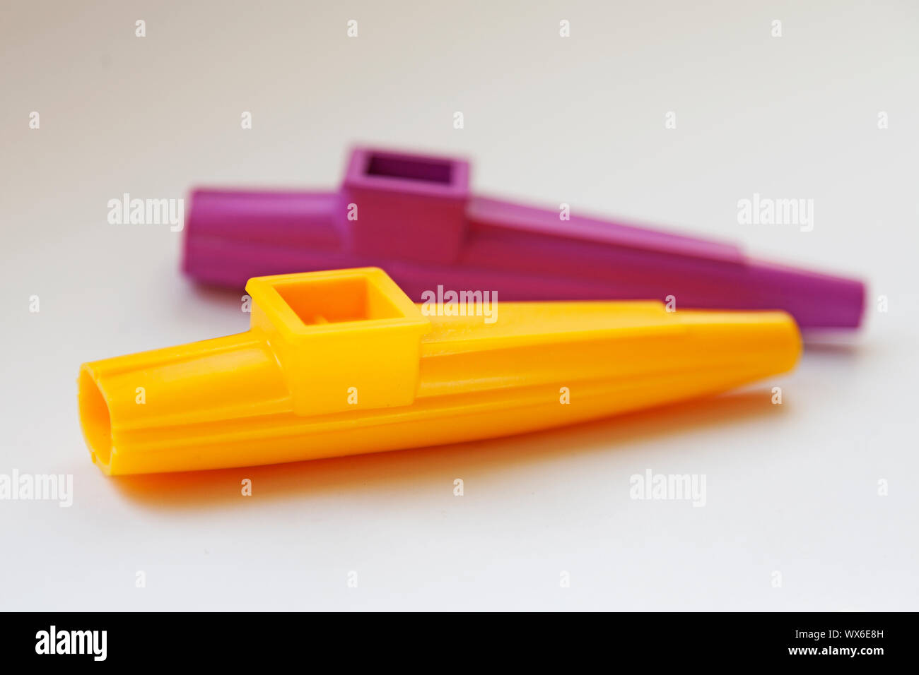 a yellow and purple kazoo on white background, a musical instrument for ...