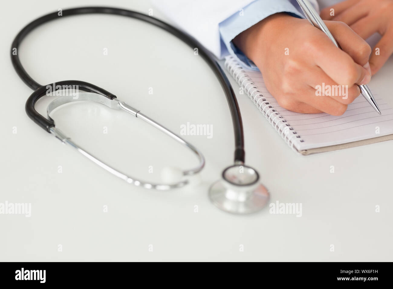 Female doctor writing on a scratchpad in her office Stock Photo - Alamy