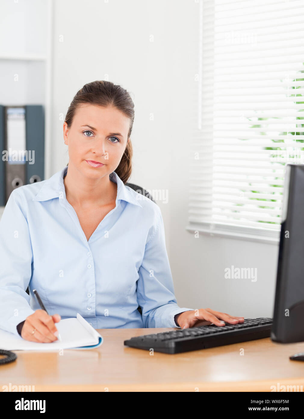 businesswoman looking into camera in her office Stock Photo - Alamy