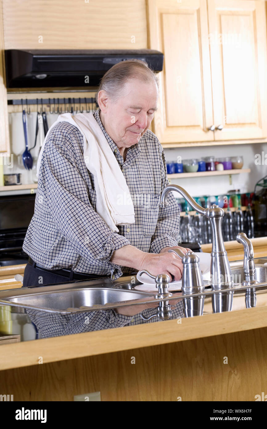 Elderly man washing dishes Stock Photo - Alamy