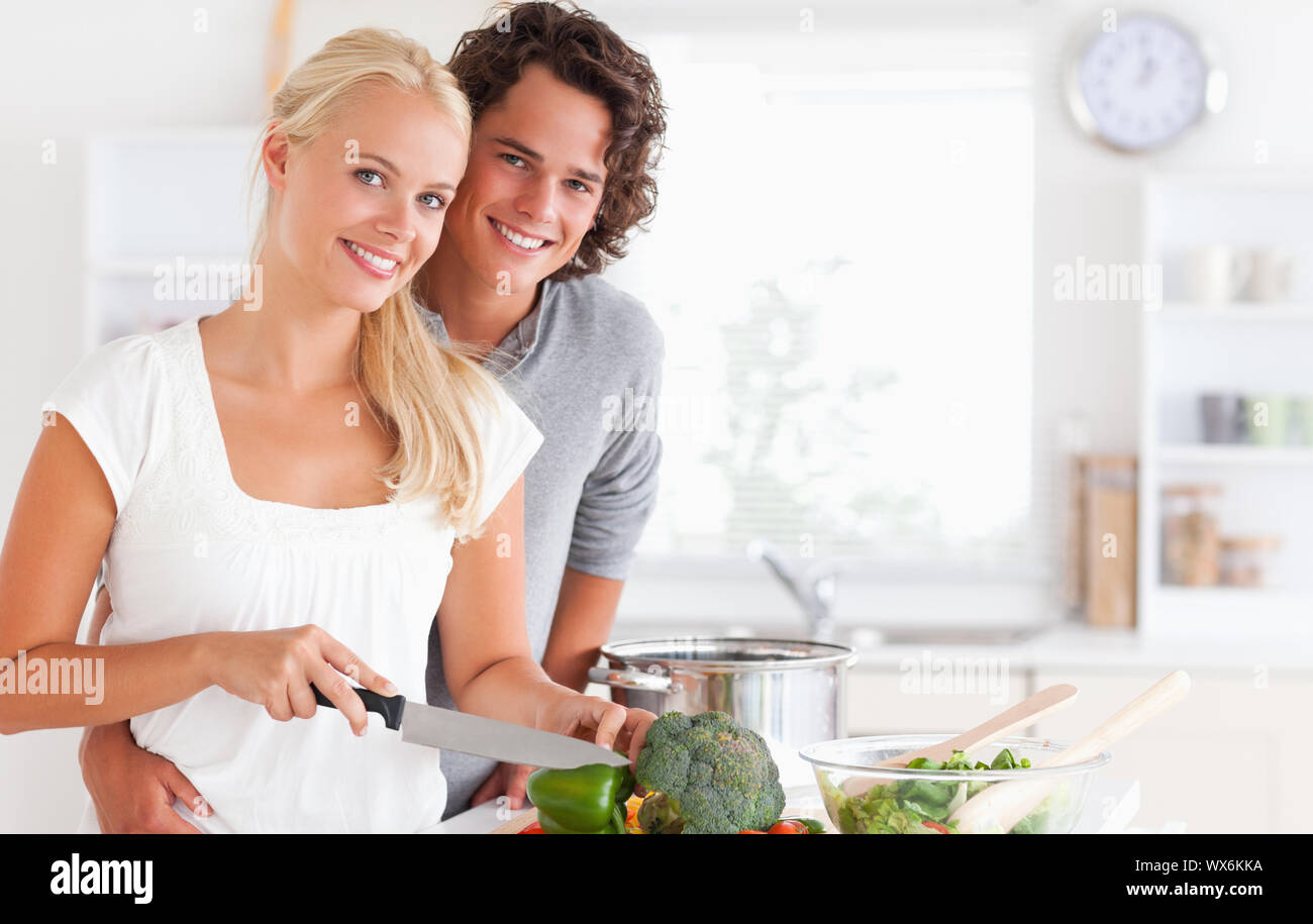 Beautiful couple cooking while looking at the camera Stock Photo - Alamy