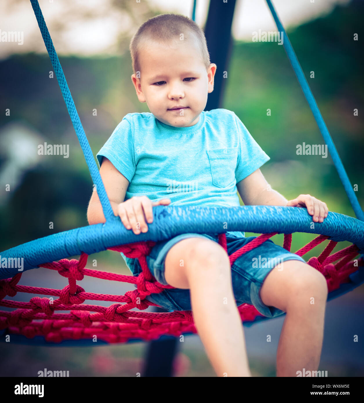 Little boy swinging on a swing Stock Photo - Alamy
