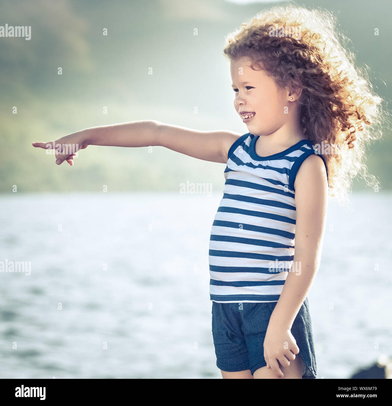 Little girl pointing near the sea Stock Photo - Alamy