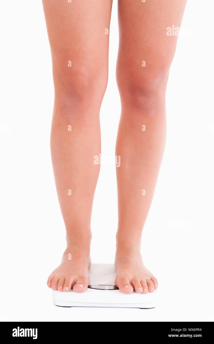 Lady standing on a scale in a studio Stock Photo - Alamy
