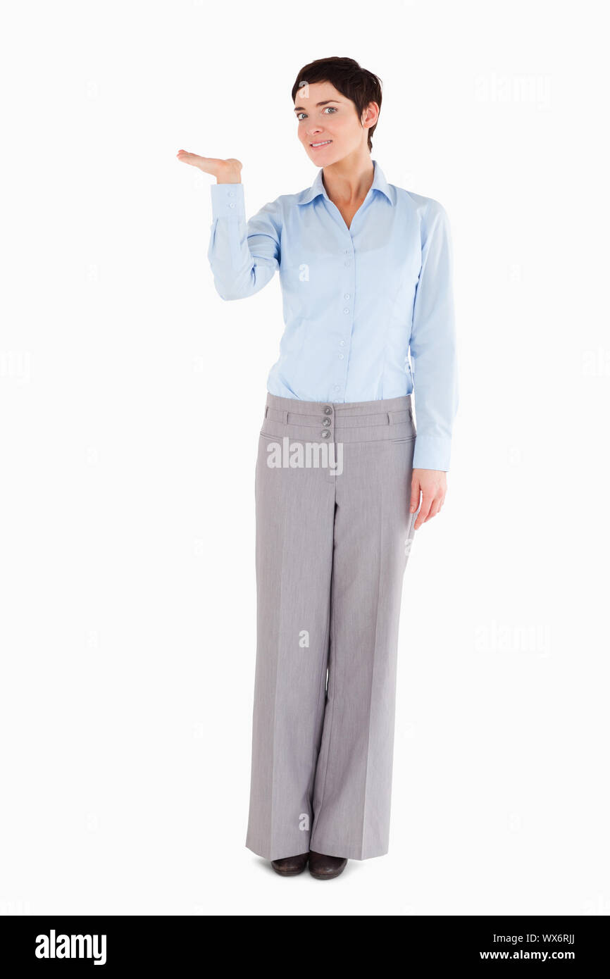 Woman with an open hand to show a copy space against a white background ...
