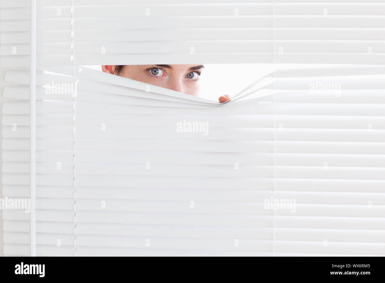 Beautiful woman peeking out window hi-res stock photography and images ...