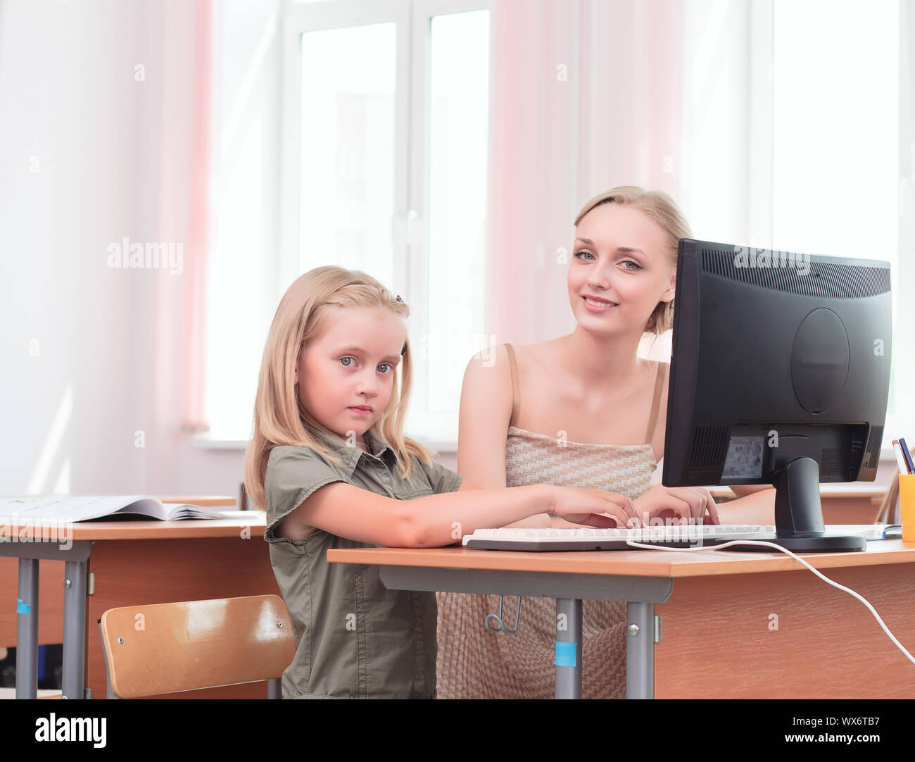 teacher explains the task schoolgirl at the computer, the new ...