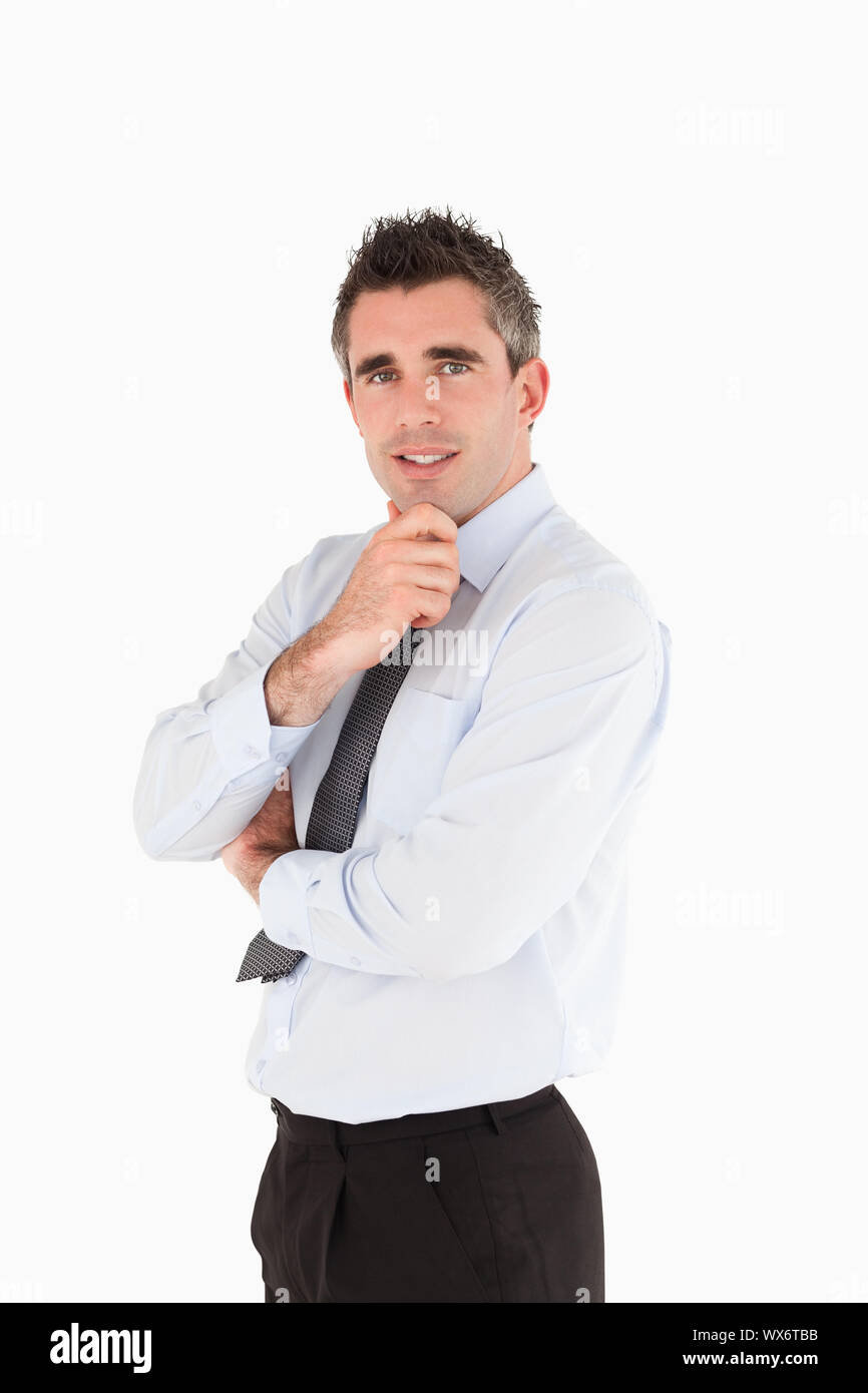 Portrait of a smiling salesperson with his hand on his chin against a ...