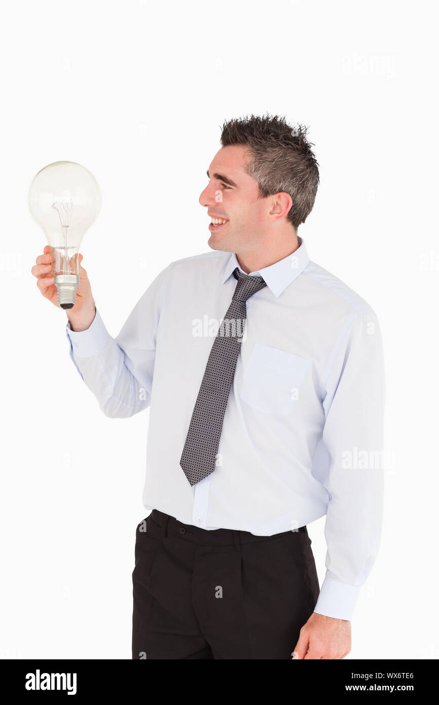 Man looking at a light bulb against a white background Stock Photo - Alamy