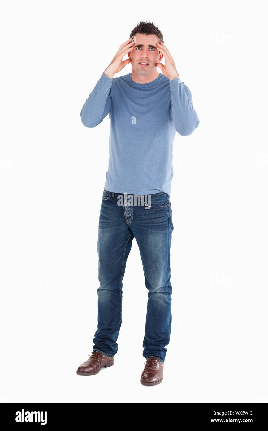 Anxious man posing against a white background Stock Photo - Alamy