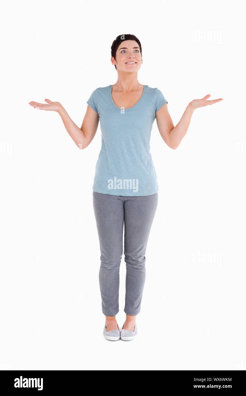 Clueless woman posing against a white background Stock Photo - Alamy