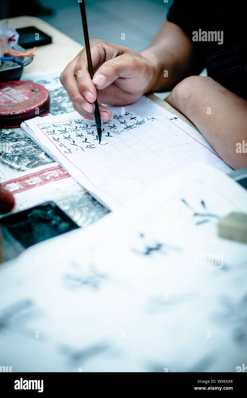 Hands writting chinese symbols on the paper, detail, close-up Stock ...