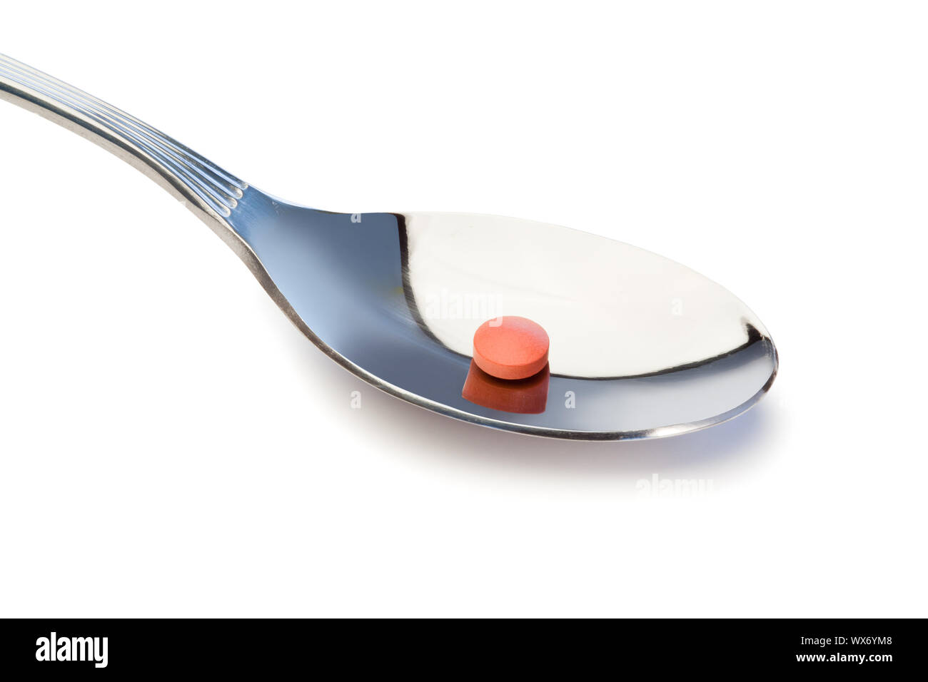 Pill in a spoon on a white background Stock Photo - Alamy