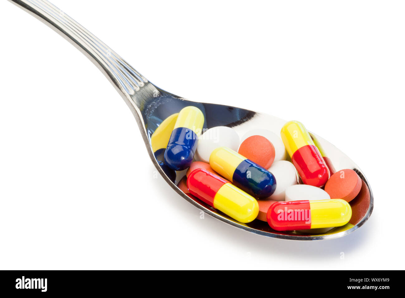 Spoon full of different kind of pills on a white background Stock Photo ...