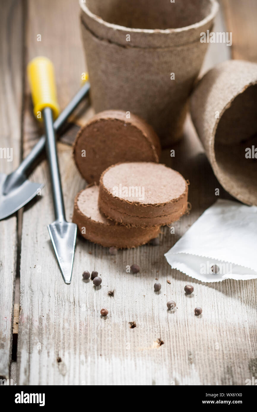 Peat bricks and pots, seeds and garden tools Stock Photo - Alamy