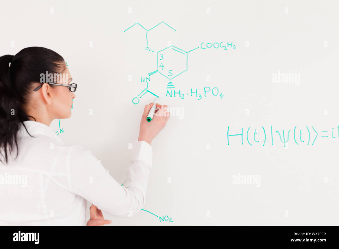 Scientist writing a formula on a white board Stock Photo - Alamy