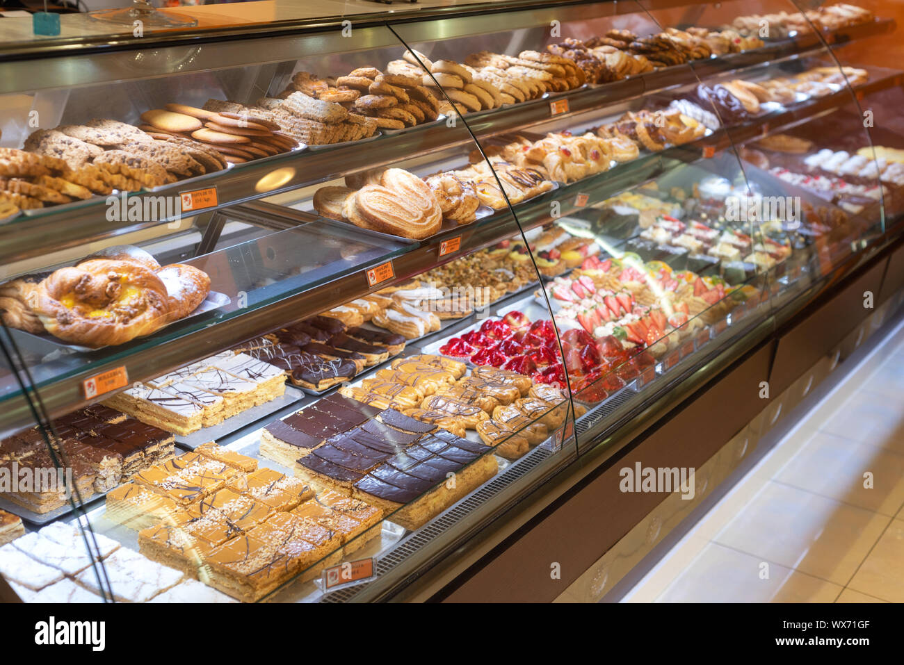 Different types of delicious cakes in pastry shop showcase Stock Photo ...